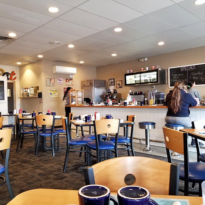 Inside, blue chairs and wooden tables create that perfect diner atmosphere where coffee flows freely and conversation never stops.