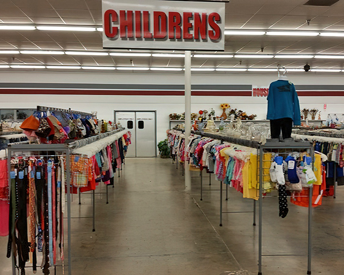 A rainbow of children's clothing stretches into the distance, each tiny garment holding the promise of playground adventures and growth spurts conquered economically.