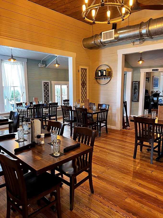Warm wooden floors, exposed beams, and that circular mirror create a space that feels both sophisticated and as comfortable as your favorite beach house.
