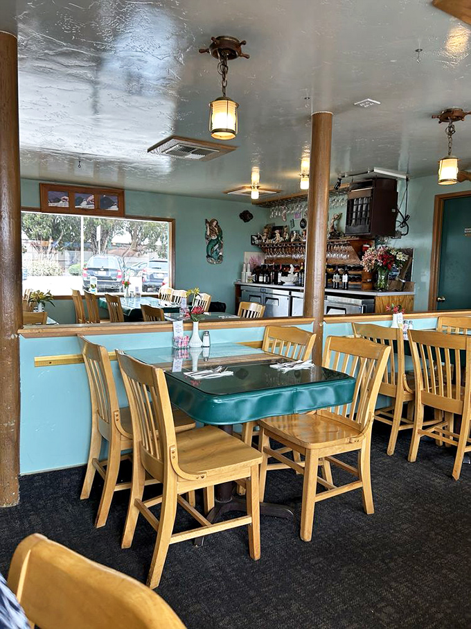 Aqua walls and wooden chairs create the perfect backdrop for seafood stories. This isn't designer chic&mdash;it's authentic coastal charm.