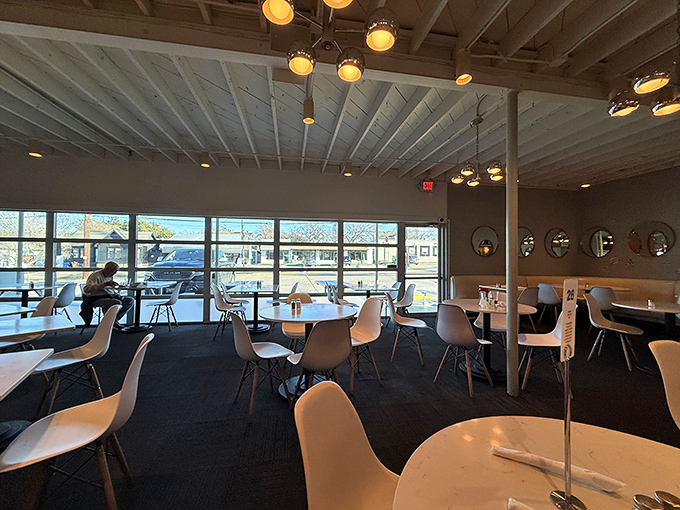 Sunlight floods through floor-to-ceiling windows, illuminating a dining room where mid-century modern meets Austin cool in perfect harmony.