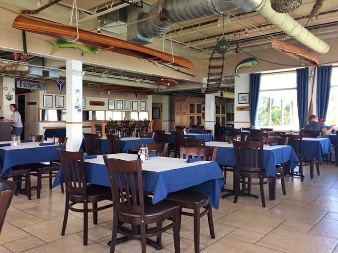 Nautical charm meets Florida sunshine in this dining room, where blue tablecloths echo the bay waters visible through those magnificent windows.
