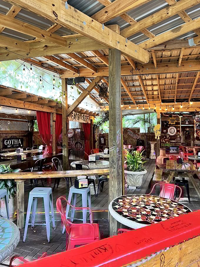 Exposed wooden beams, string lights, and colorful chairs create a space that's equal parts rustic barn and enchanted garden party.