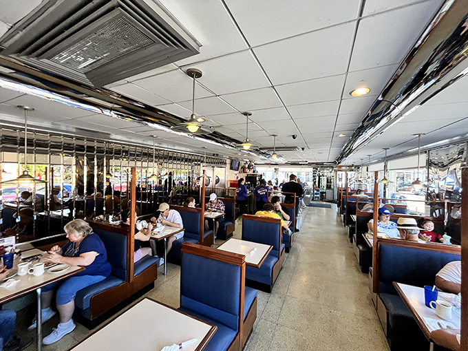 Classic blue booths and mirrored walls create that timeless diner atmosphere where conversations flow as freely as the coffee.