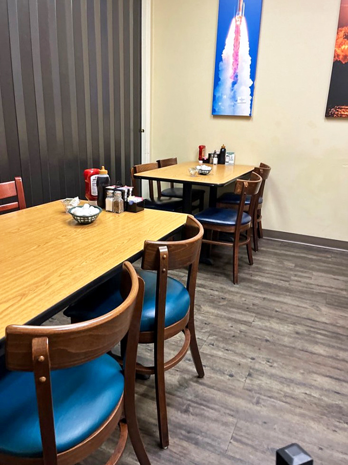 Simple wooden tables and blue chairs create an unpretentious dining space where the rocket artwork reminds you that on the Space Coast, even breakfast has a cosmic connection.
