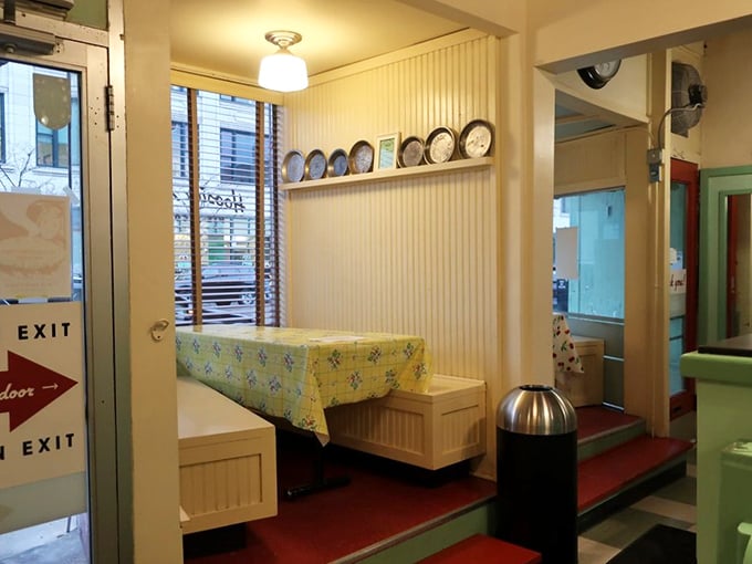 Exposed brick walls meet modern comfort inside Harbor Halcyon, where pendant lighting casts a warm glow over leather seating and a distinctive blue patterned floor.