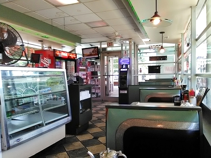 Step inside and time travels backward – classic checkered floors, vintage display case, and that unmistakable diner glow that says "calories don't count here."