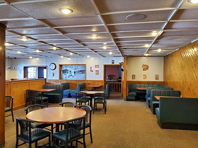 Wood paneling and green booths create that classic small-town restaurant vibe where conversations flow as freely as the coffee.