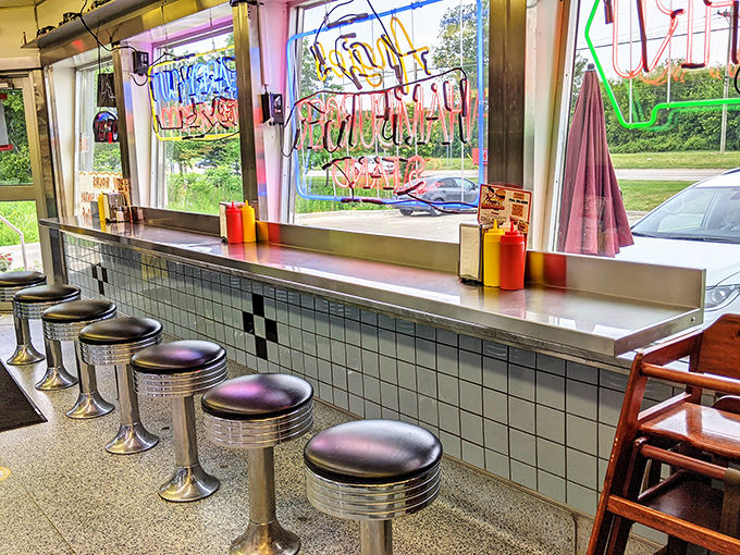Those classic diner stools aren't just seats – they're front-row tickets to watching burger magic happen before your eyes.