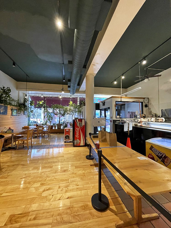 Warm wooden floors, exposed ductwork, and abundant greenery create an atmosphere that's simultaneously cozy and energizing—like dining in your coolest friend's living room.