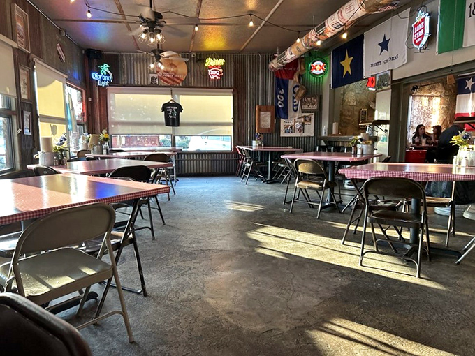 Inside, corrugated metal meets Texas pride with checkered tablecloths and neon beer signs creating that perfect "I've found the real deal" barbecue atmosphere.