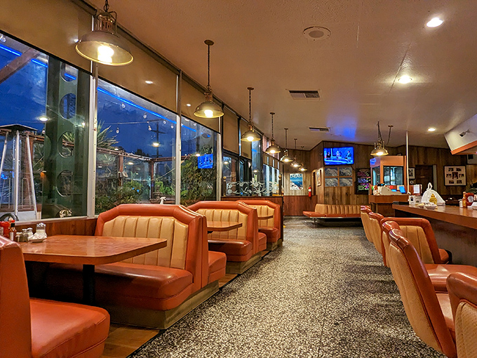 Orange vinyl booths and terrazzo floors create a time capsule where comfort food reigns supreme.