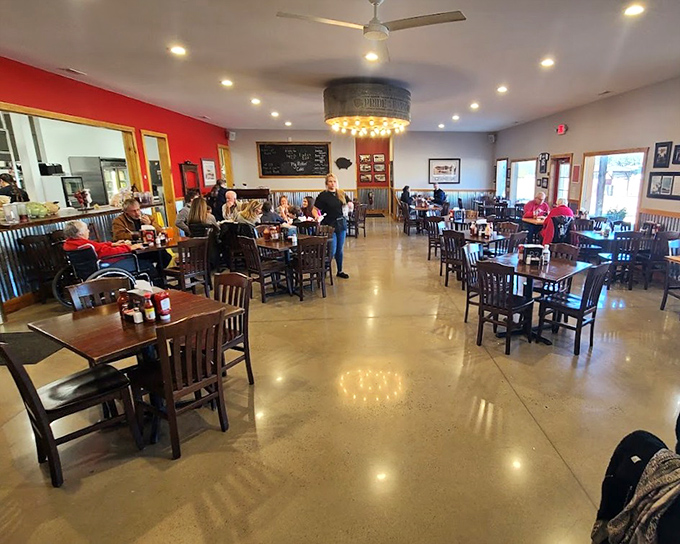 The bright interior balances casual comfort with spaciousness. Red walls and wooden furniture create the perfect backdrop for the barbecue feast to come.