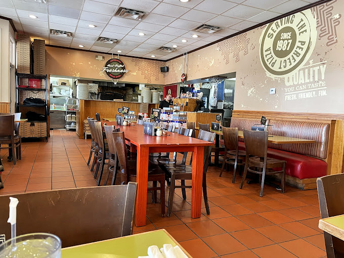 Inside, terra cotta floors and wooden tables create that perfect "come as you are" vibe where pizza memories are made.