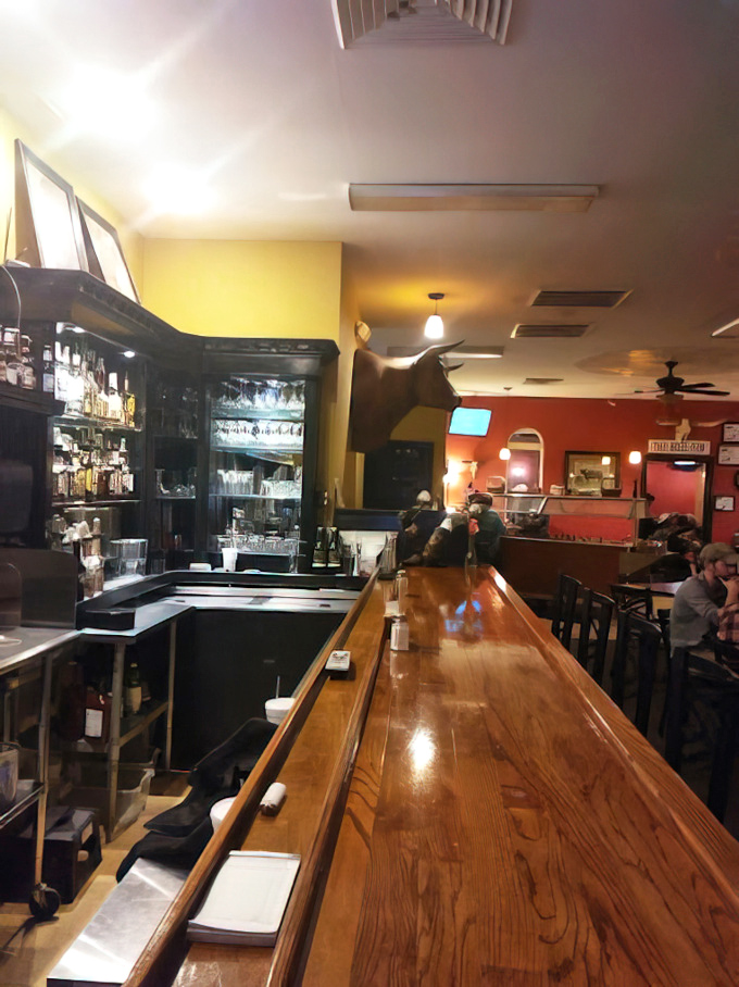 The gleaming wooden bar isn't just furniture&mdash;it's a front-row seat to the steakhouse symphony that unfolds nightly. 