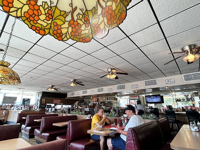 Where stained glass lamps cast a warm glow over vinyl booths that have hosted decades of morning conversations and coffee refills.