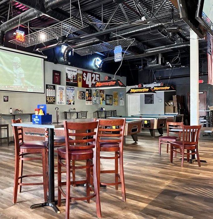 Inside, wooden floors and industrial ceilings create that rare sports bar vibe where conversations flow as freely as the beer.