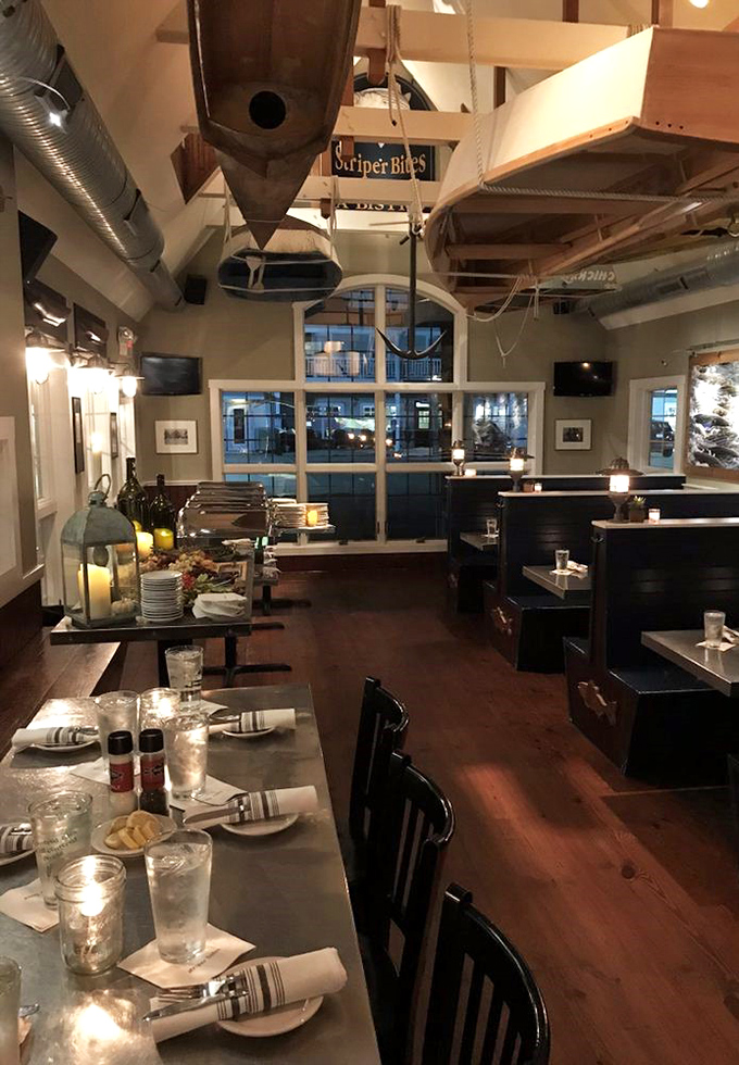 Suspended boat hulls and warm wooden beams create a dining room that feels like being inside a particularly delicious ship. Maritime magic meets mealtime.