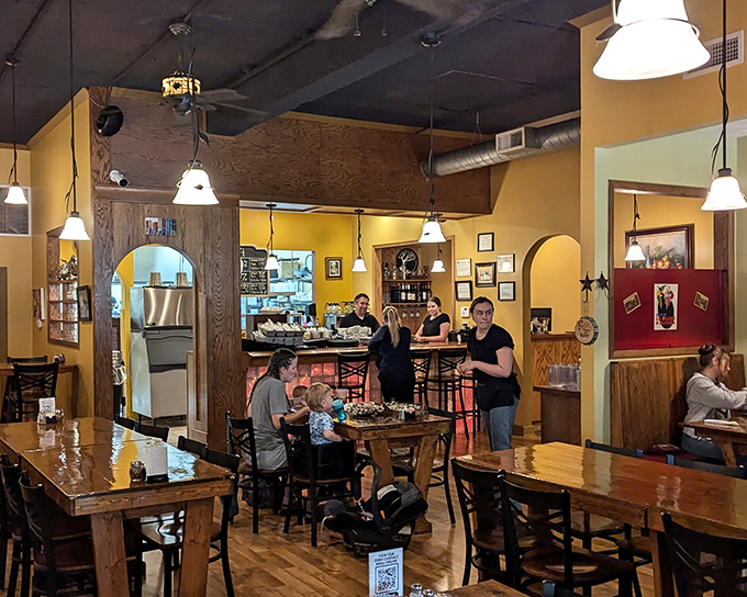 Warm yellow walls, wooden tables, and pendant lighting create that rare atmosphere where you instantly feel like a regular, even on your first visit.