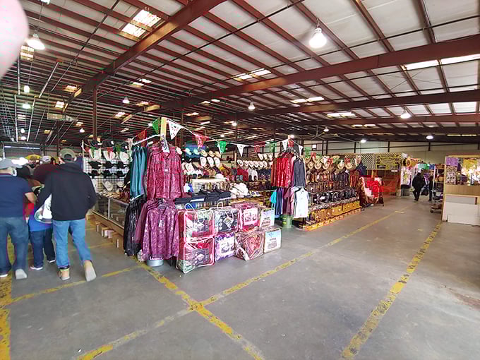 Yellow floor lines guide treasure hunters through this vast indoor bazaar where colorful clothing displays and eager shoppers create a vibrant tapestry of commerce.