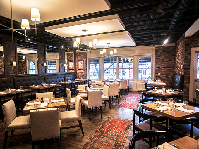 Exposed brick walls meet elegant lighting in this dining room where comfort and sophistication share equal billing. Somewhere between "fancy night out" and "welcome home."
