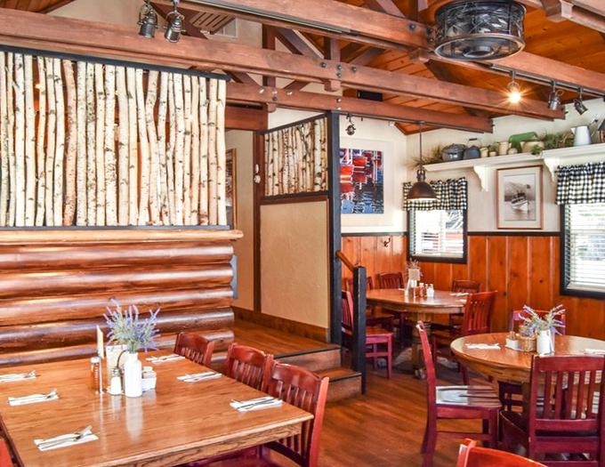 Rustic wooden beams, birch accents, and checkered curtains create the perfect mountain breakfast sanctuary.