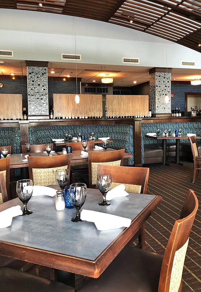 Inside, modern meets maritime with blue-patterned booths and warm wood tables—a dining room that says "we're fancy, but your jeans are fine."