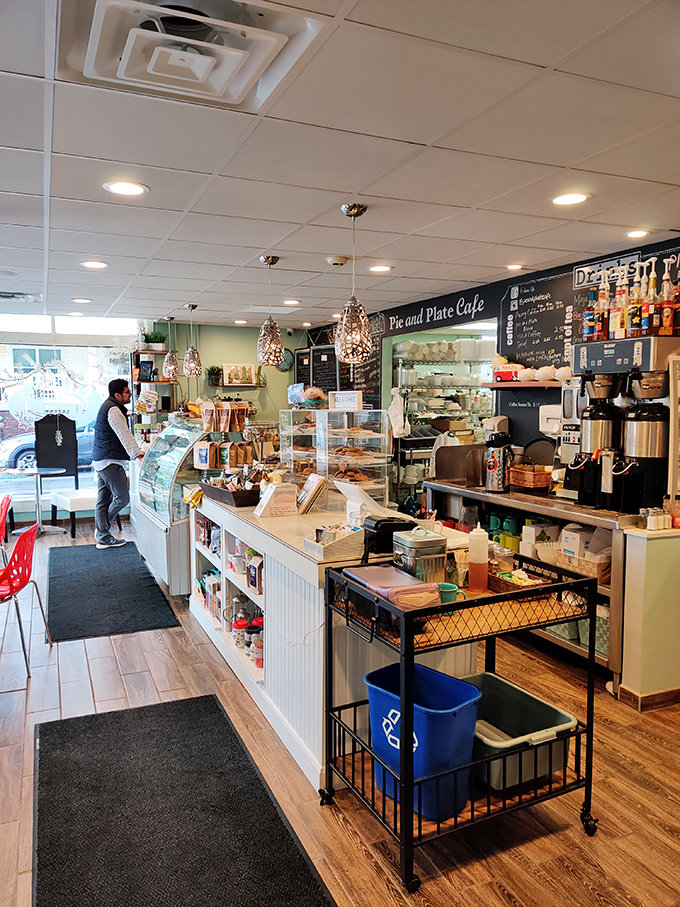 Inside this quiche sanctuary, pendant lights cast a warm glow over display cases filled with temptations that would make any diet plan nervously clear its throat.