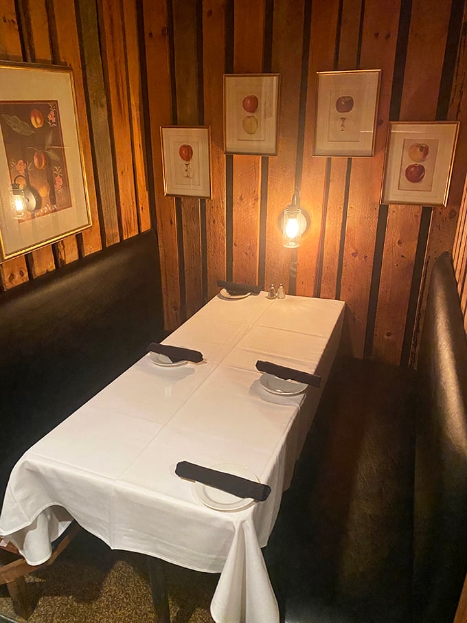 Cozy wooden booths bathed in warm lantern light create intimate dining spaces that feel like your own private farmhouse retreat.
