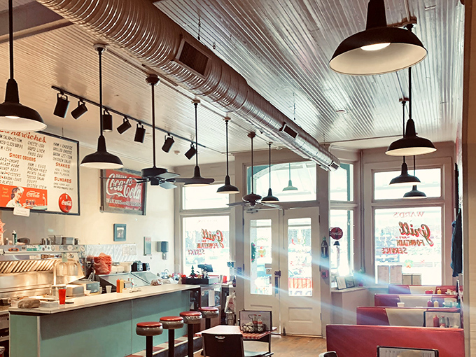 Sunlight streams through windows illuminating a diner straight from America's golden age. Those red booths have cradled more stories than a library. 