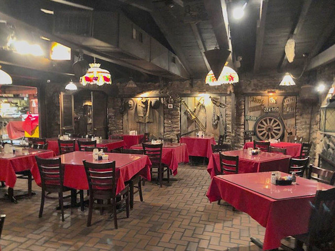Red tablecloths signal serious steak business ahead, while stone walls and Tiffany lamps create the perfect atmosphere for carnivorous contemplation.