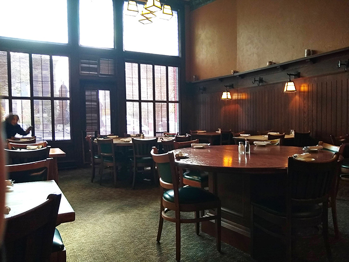 Step inside this timeless tavern where dark wood meets warm light in dining room harmony.