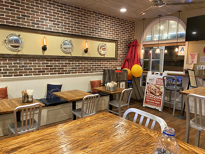 Nautical touches like porthole mirrors and exposed brick create that perfect "I've just stepped into a New England seafood shack" feeling.