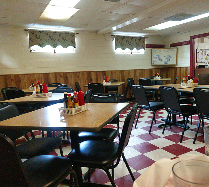 Classic red and white checkered floors meet wood-paneled walls, creating that timeless diner atmosphere where conversations flow as freely as the coffee.