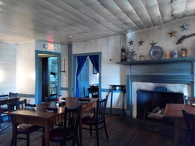 Blue trim and exposed beams frame a dining room where George Washington could walk in and feel right at home. The fireplace isn't just decorative&mdash;it's been warming diners for centuries.