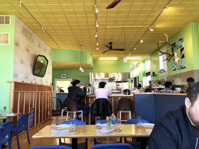 Mint-green walls and golden ceiling tiles create a cheerful atmosphere where morning magic happens at the counter and beyond.