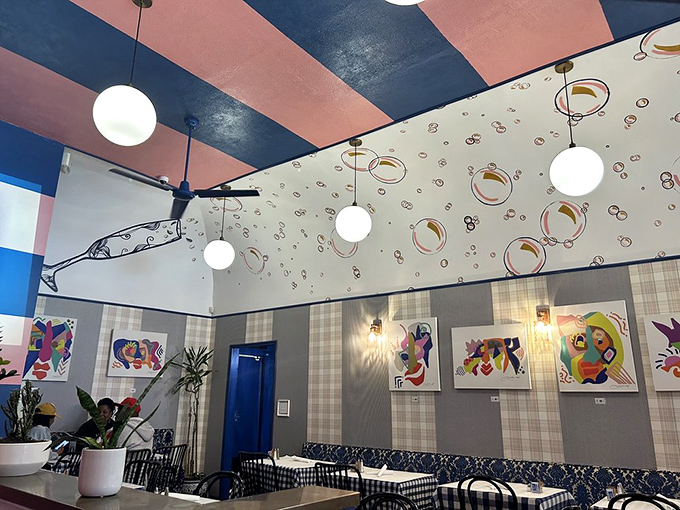 Pink and blue stripes dance across the ceiling while bubble motifs and modern art create a space that's equal parts playful and sophisticated.