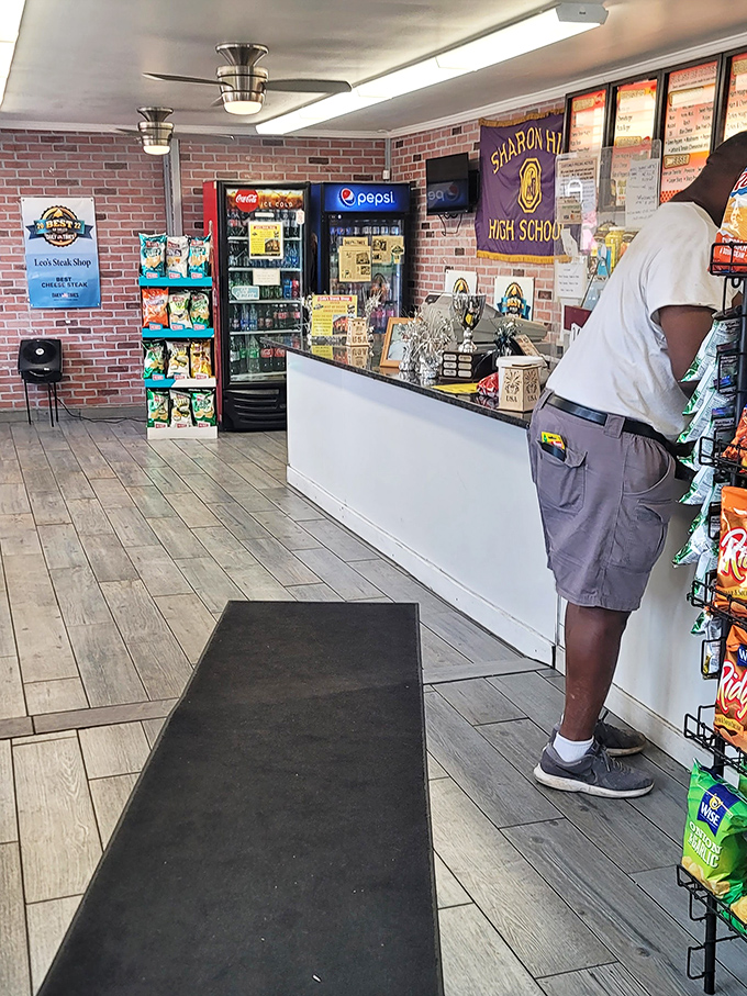 No-frills interior where culinary magic happens. The Sharon Hill High School banner reminds you this is deeply rooted community food at its finest.