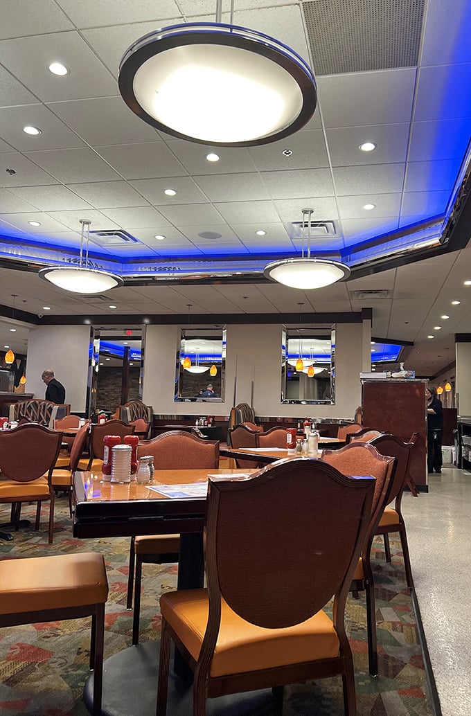 Blue neon lighting transforms an ordinary ceiling into a retro-futuristic canopy where coffee flows and breakfast dreams come true.