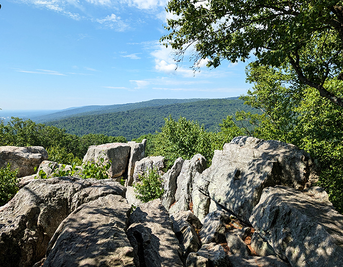 Rock formations that look like nature's own modern art installation, with a backdrop of endless green mountains stretching to the horizon.