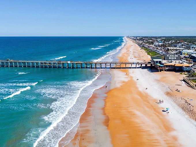Cinnamon-colored sand meets Atlantic blue, with that iconic wooden pier stretching toward the horizon like a welcome mat.
