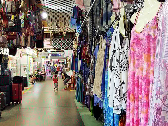 Red Barn's vibrant clothing displays create a rainbow of fashion possibilities under rustic wooden beams.