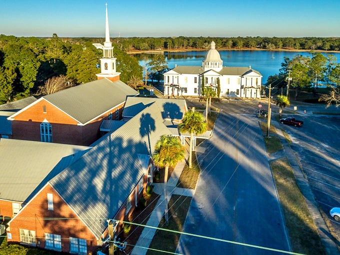 Victorian elegance meets small-town charm where white church steeples rise above DeFuniak Springs' mirror-like waters.