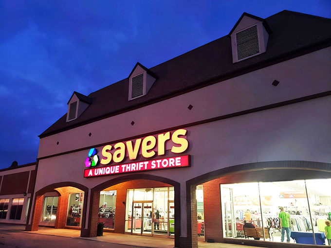 As dusk approaches, Savers' illuminated storefront beckons night owls to hunt for vintage treasures under the glow of fluorescent lights.