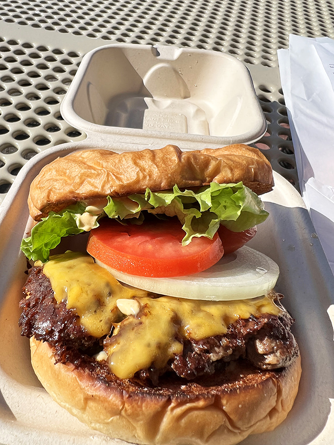Behold burger nirvana: a perfectly charred patty, melted cheese, fresh veggies, and that toasted bun. This is what dreams are made of.