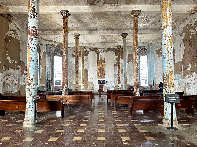 The chapel's peeling paint and weathered columns tell silent stories of prayers whispered by thousands seeking redemption behind these walls. 