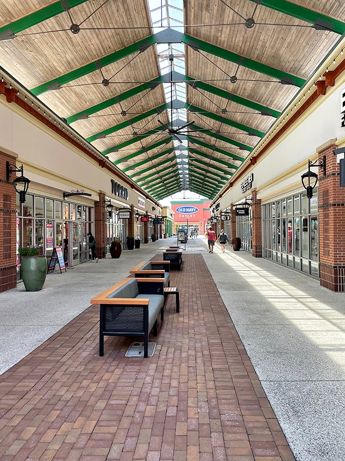 Wooden beams arch gracefully overhead in this covered walkway, creating a shopping cathedral where retail devotees can worship at the altar of discounts.