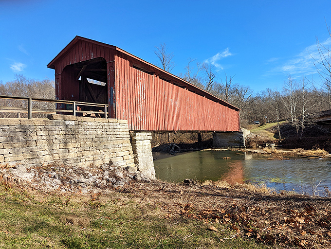 Sunlight plays across the rustic red exterior, highlighting the craftsmanship that's weathered nearly 150 years of Indiana seasons.