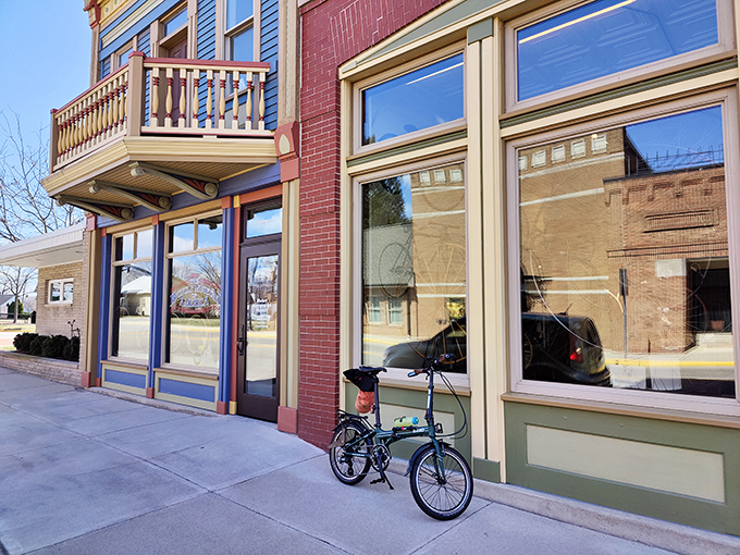 A modern folding bike rests against the museum's historic storefront. Even the bicycles make pilgrimages to this shrine of cycling history.