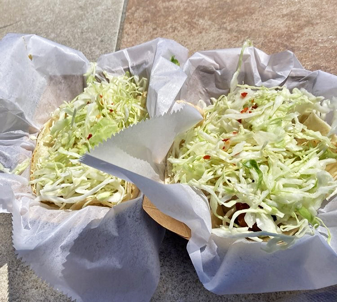 Simplicity perfected: Fresh cabbage piled high on corn tortillas, ready for that first bite that transports you straight to coastal bliss.